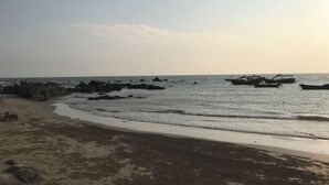 Uma praia com barcos e pedras.