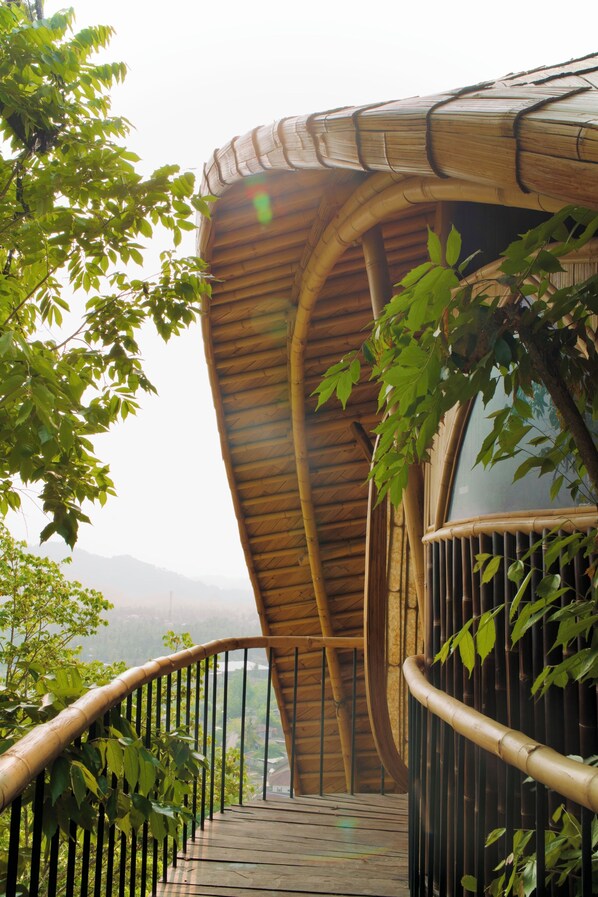 Uma estrutura de madeira com telhado curvo e deck de madeira com guarda-corpos.