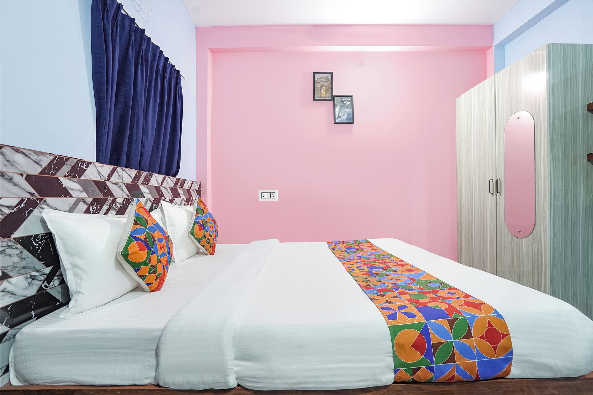 Quarto com cama, almofadas, guarda-roupa e uma porta.