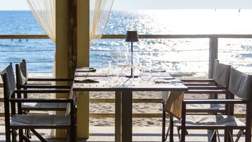 Na praia, espreguiçadeiras, guarda-sóis de praia, windsurf