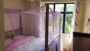 Quarto com uma cama, janela e escrivaninha.