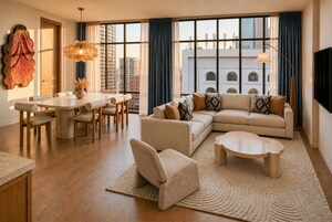 Uma sala de estar moderna com sofá, mesa de centro e área de jantar.