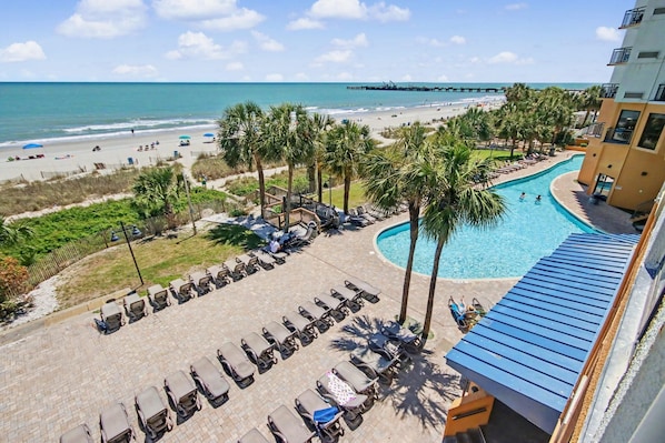 Um resort com piscina, praia e vista para o oceano.