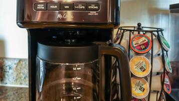 Máquina de café com painel digital, jarra de vidro transparente e nome da marca na base.