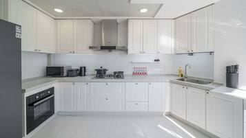 Apartamento superior, 3 quartos, sacada, vista para a cidade | Cozinha privada | Geladeira, micro-ondas, cooktop, talheres/pratos/utensílios de cozinha