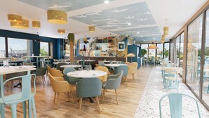 A modern restaurant with round tables, chairs, and a ceiling with a bird mural.