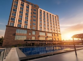 Hotel moderno com uma piscina grande e vista para o pôr do sol.