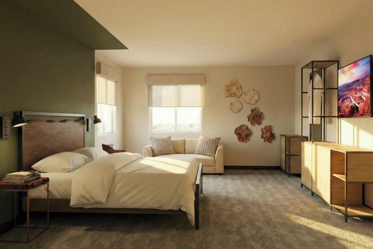 Quarto com cama, sofá, televisão e decoração nas paredes.
