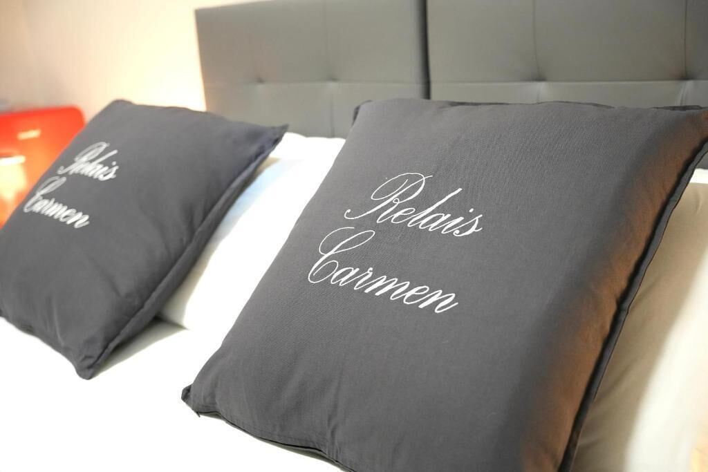 Uma cama com dois travesseiros, um com a inscrição "Rita's Carmen" e outro com a inscrição "Rita's Carmen".
