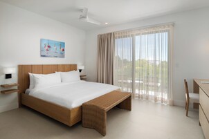 Quarto moderno com cama de madeira, uma janela grande com cortinas leves e um ventilador de teto.