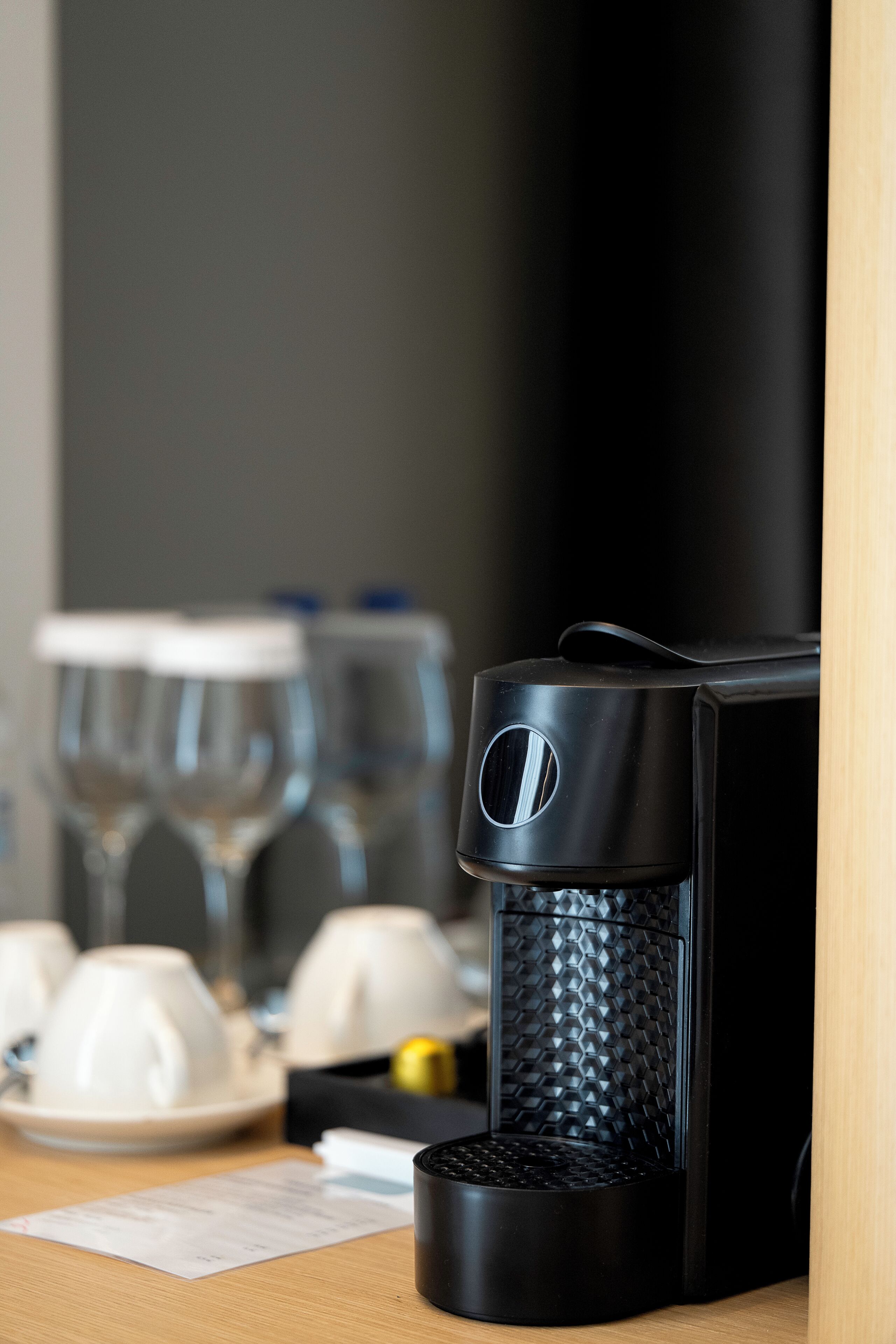 Uma máquina de café sobre uma mesa, com um cardápio e um copo de água.