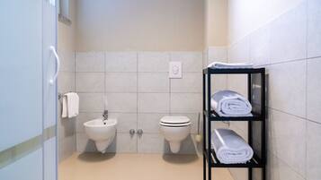 Uma casa de banho moderna com duas pias, uma sanita e um porta-toalhas.