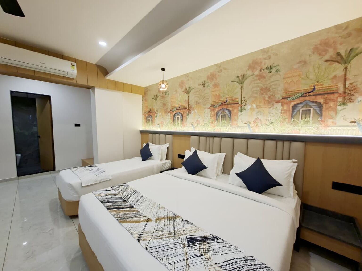 Quarto de hotel com duas camas, um mural e design moderno.