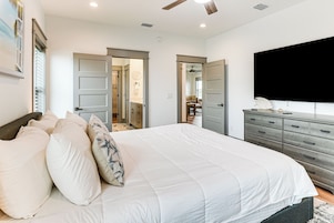 Quarto com uma cama grande, cômoda e televisão de tela plana.