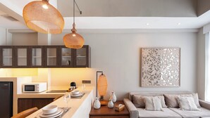 Uma cozinha moderna com área de refeições, sofá e um painel decorativo na parede.