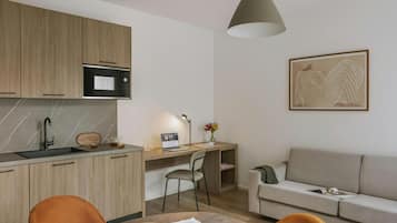 Suíte estúdio superior, 1 cama King e sofá-cama, cozinha | Cozinha privada | Frigobar, micro-ondas, cooktop, lava-louças