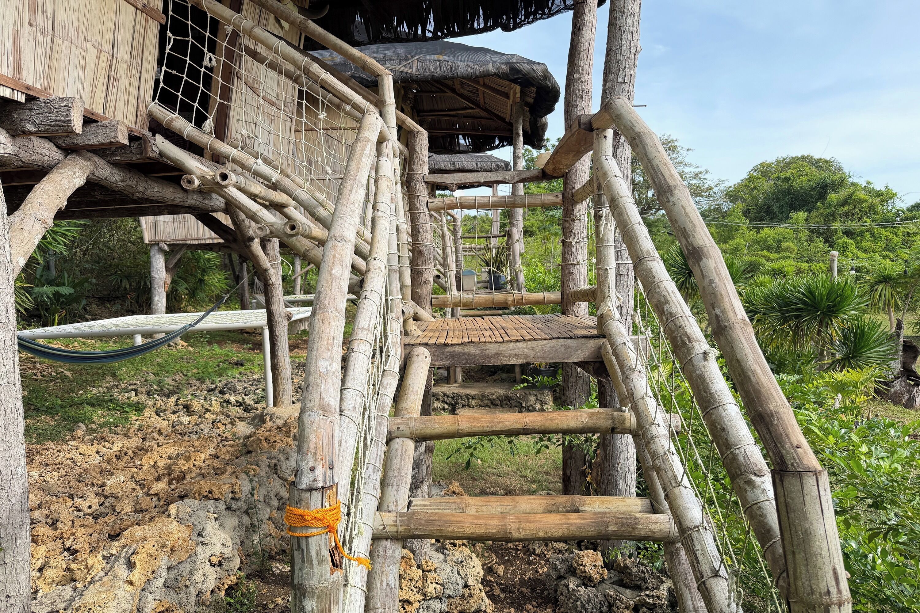 Estrutura de bambu com plataforma de madeira e telhado de palha.