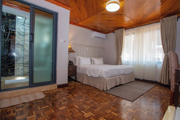 Quarto Duplo ou Twin Deluxe, 1 cama king-size, ar condicionado, vista para o jardim | Cofre com capacidade para portátil, secretária