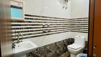 Chuveiro, toalhas de banho, sabonete, papel higiênico