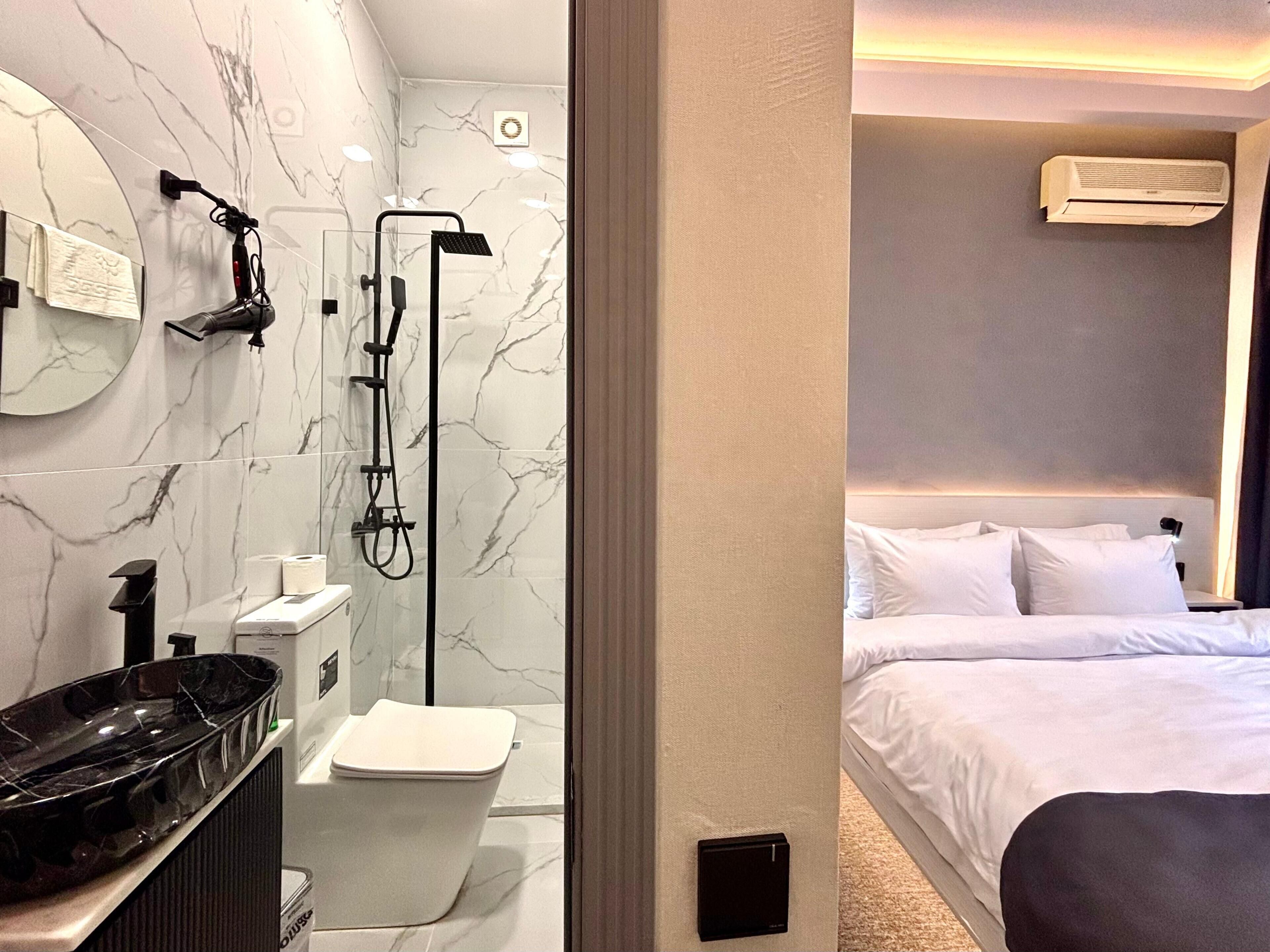 Quarto Duplo Deluxe, vista para o jardim | Casa de banho | Um secador de cabelo, chinelos, toalhas fornecidas, sabão 