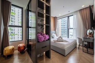 Quarto de hotel moderno com uma cama grande, uma escrivaninha e uma estante.