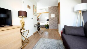Uma sala de estar moderna com televisão de tela plana, sofá, mesa de centro e tapete estampado.