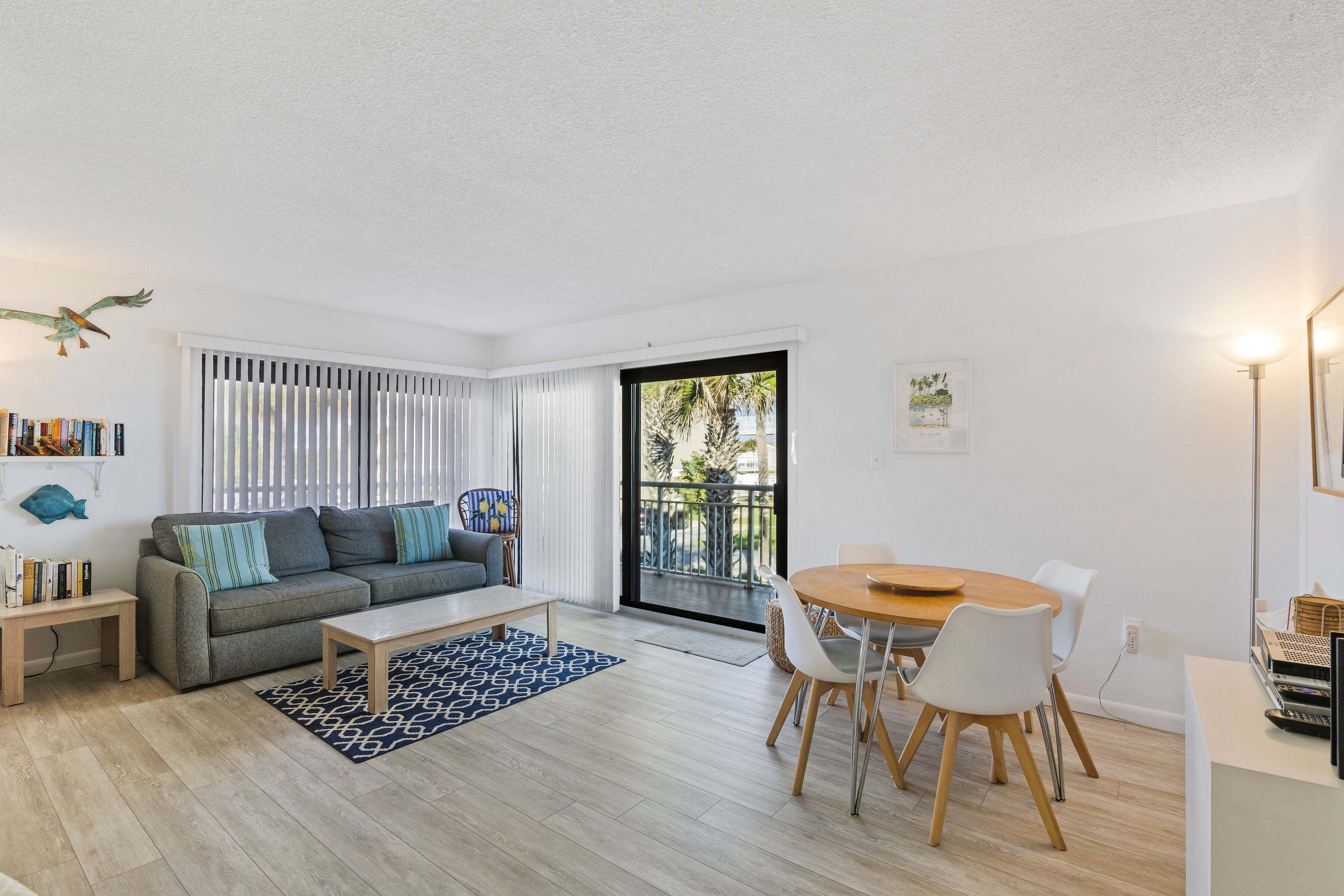 Uma sala de estar moderna com sofá, mesa de centro e área de jantar.