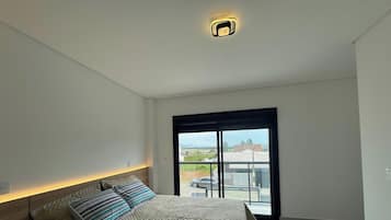 Quarto com cama, janela e luminária no teto.