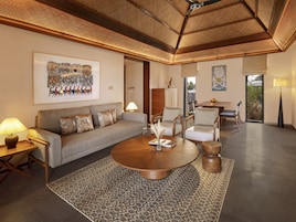 Uma sala de estar moderna com um sofá, poltronas, uma mesa de centro e um espaço de jantar.