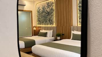 Quarto de hotel com duas camas, ventoinha no teto, um mural grande na parede e chão de madeira.