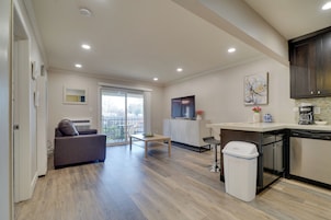 Um apartamento moderno com sala de estar, área de jantar, cozinha e varanda.