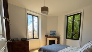Um quarto com cama, penteadeira e lareira.