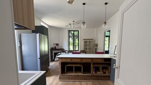 Uma cozinha moderna com piso de madeira, ilha central e luminárias pendentes.