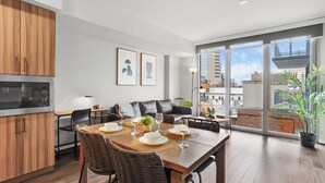 Cozinha moderna com armários de madeira e área de jantar com mesa posta para quatro pessoas.