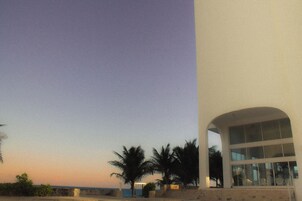 Um edifício com uma grande janela em arco e vista para o oceano.