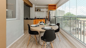 Uma cozinha moderna com área de jantar, janelas amplas e varanda.