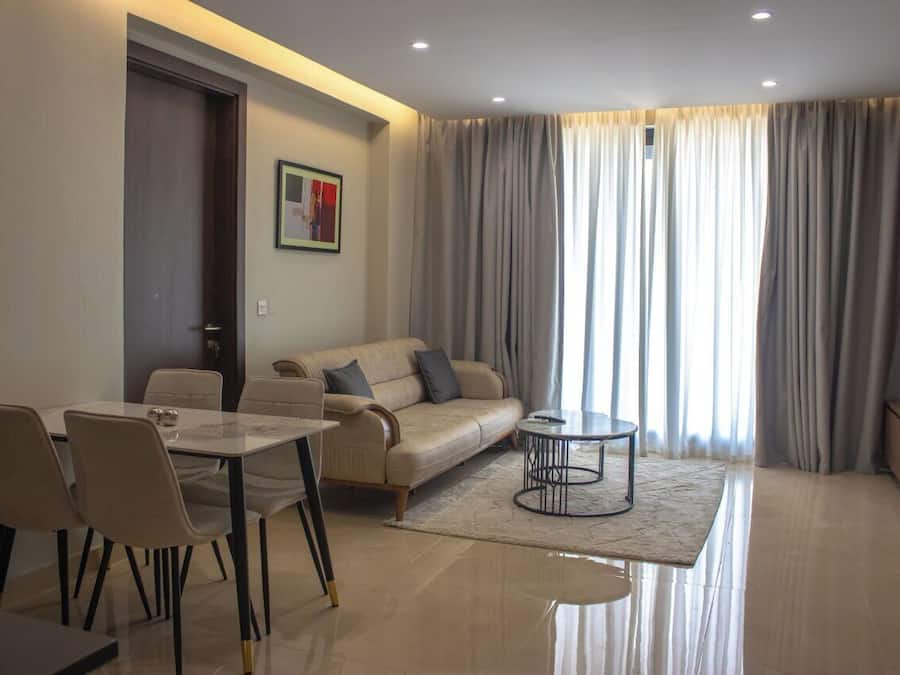 Uma sala de estar moderna com sofá, mesa de jantar, cadeiras e mesa de centro.