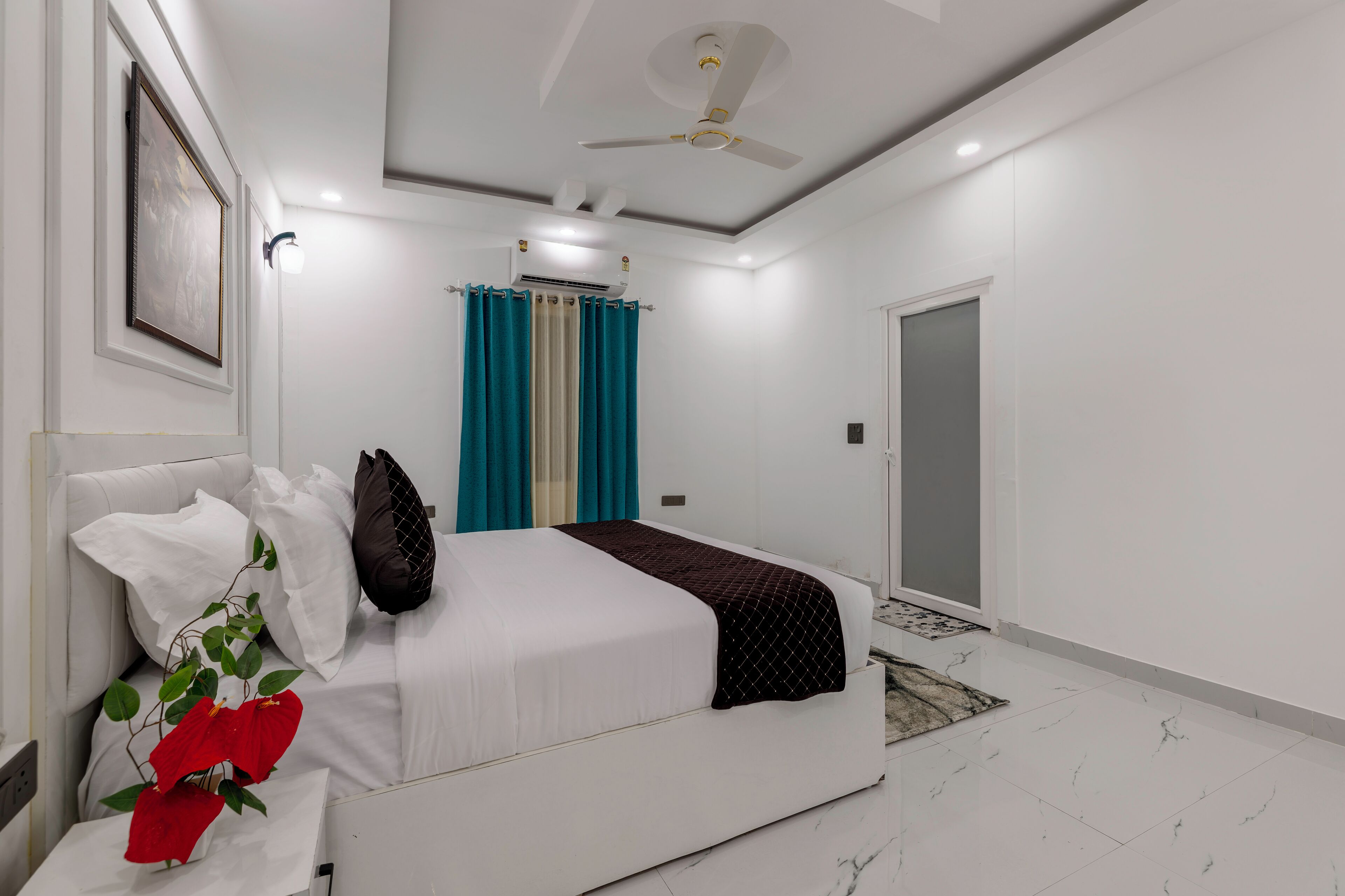 Um quarto moderno com uma cama, um ventilador de teto, uma janela com cortinas e uma porta.