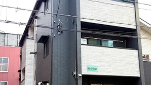 Um edifício moderno de dois andares com uma placa indicando ser um hotel.