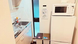 Uma cozinha compacta equipada com micro-ondas, pia e armários.