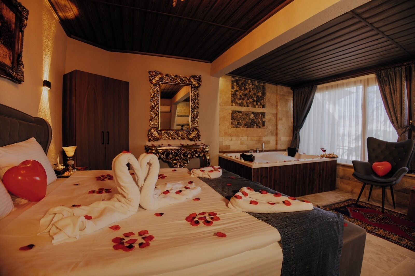 Quarto de hotel com cama, banheira, cadeira e espelho.