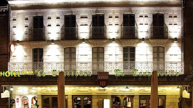 Um hotel com área de refeições e mesas ao ar livre.