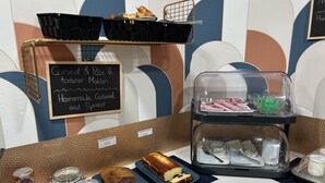 Buffet de café da manhã com placa indicando os itens disponíveis.