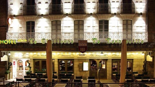 Um hotel com área de refeições e mesas ao ar livre.