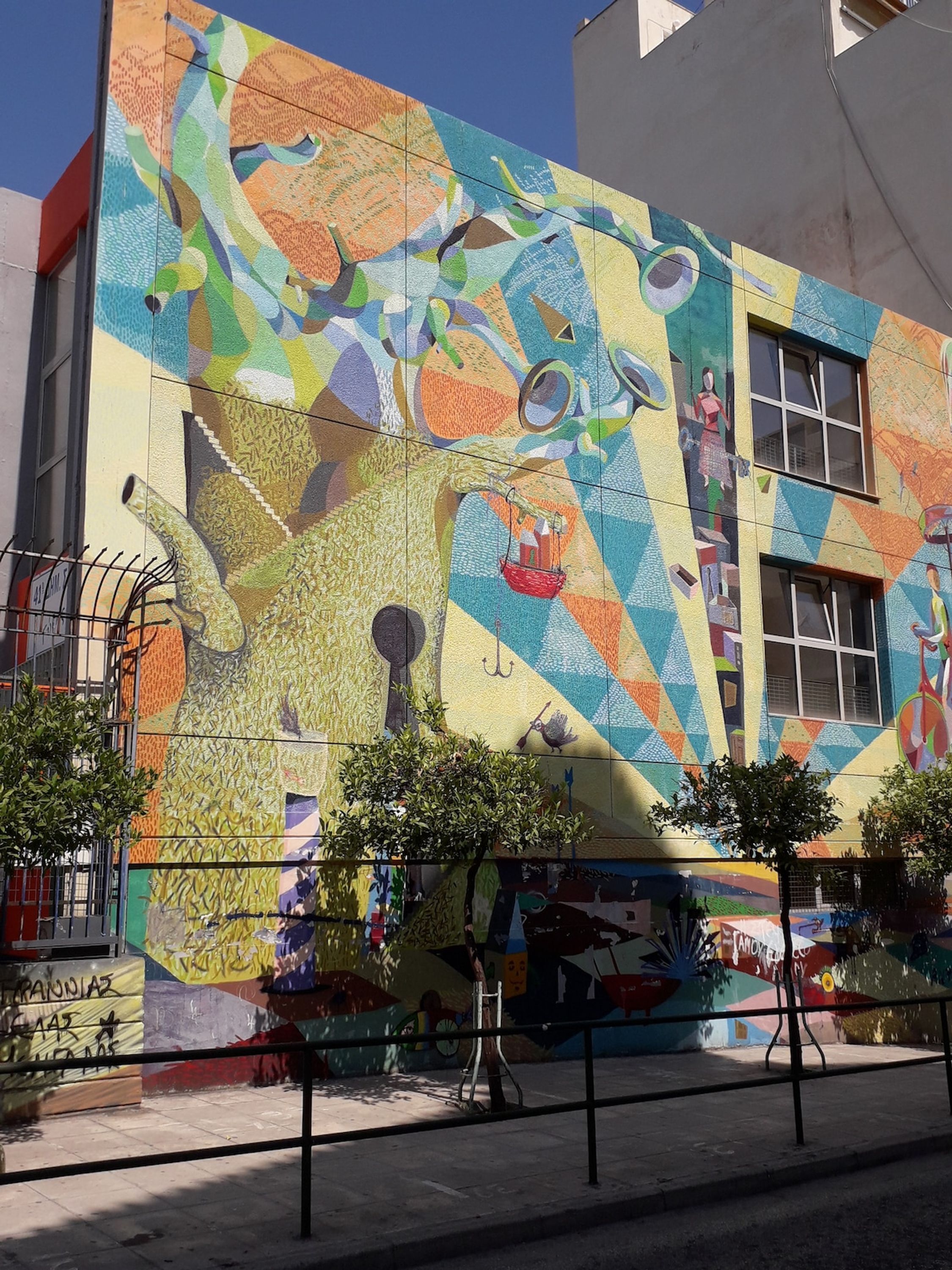 Um edifício com um mural colorido em mosaico na fachada.