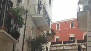 Uma escadaria de pedra leva a um edifício com fachada vermelha.