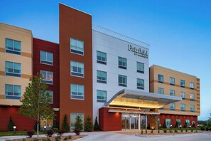 Um hotel Fairfield by Marriott de vários andares com design moderno, apresentando uma entrada destacada com galeria coberta.