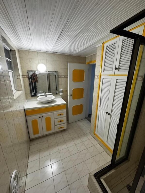 Uma casa de banho com lavatório, espelho e armários.
