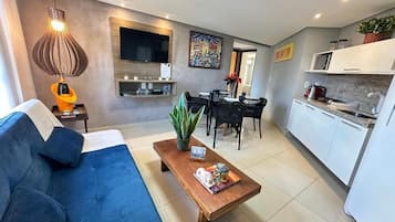 Apartamento família, para não fumantes, vista para a piscina | Área de estar | TV de tela plana 43 polegadas com canais digitais