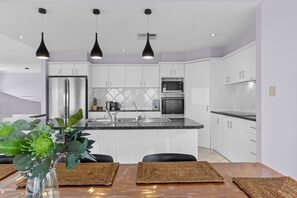 Apartamento | Cozinha privada | Uma cadeira de bebé, utensílios de cozinha 